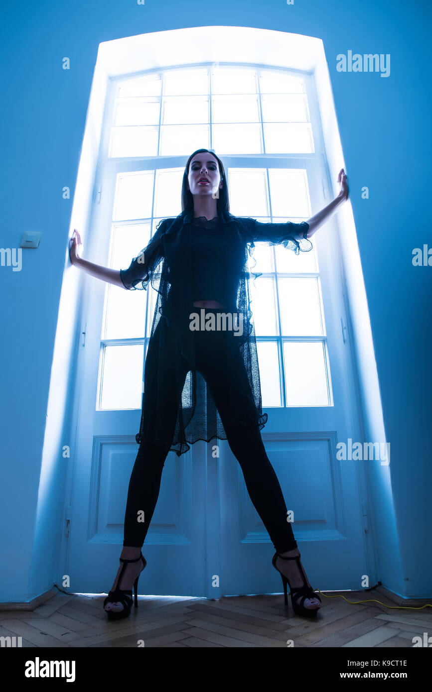 Portrait of a beautiful young woman leaning against a door Stock Photo ...