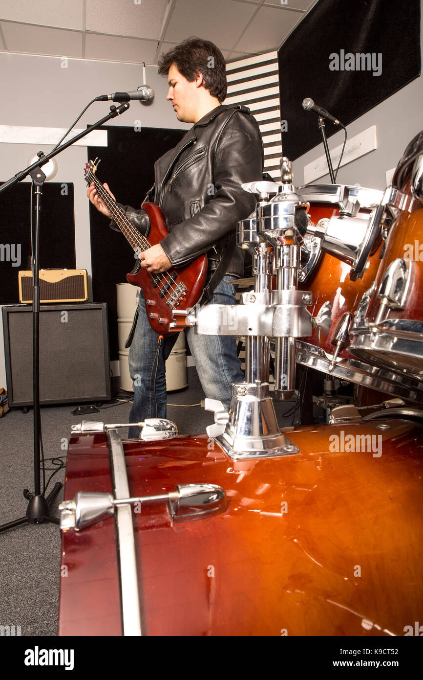 A Rock musician playing passionately bass in the rehearsal Studio Stock ...
