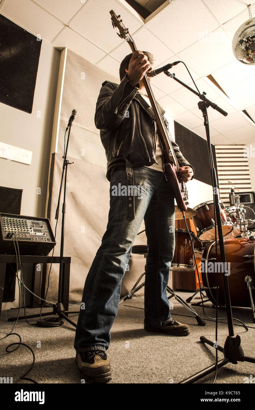 A Rock singer playing bass in the rehearsal Studio Stock Photo - Alamy