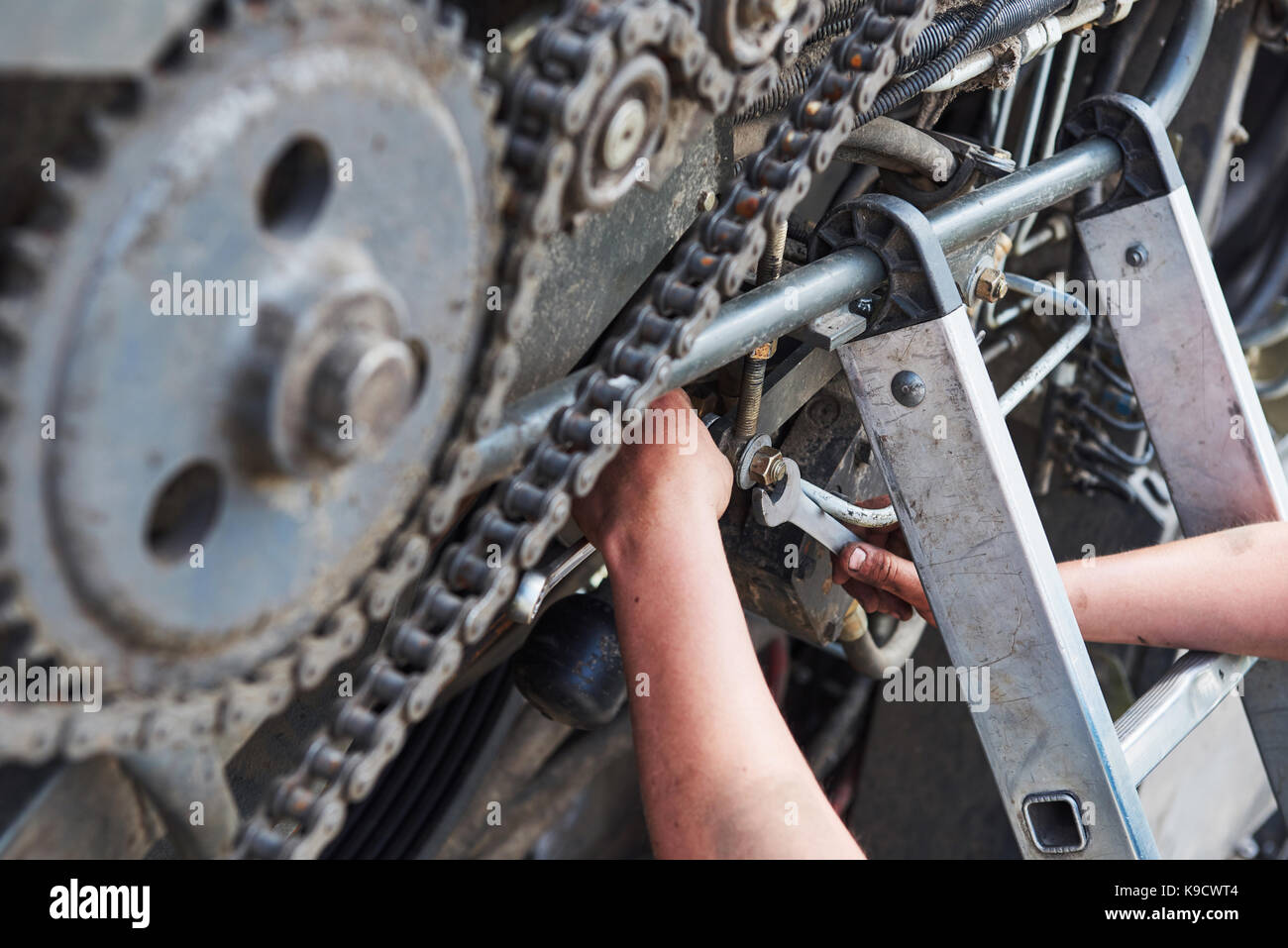 Combine machine service, mechanic repairing motor outdoors Stock Photo ...