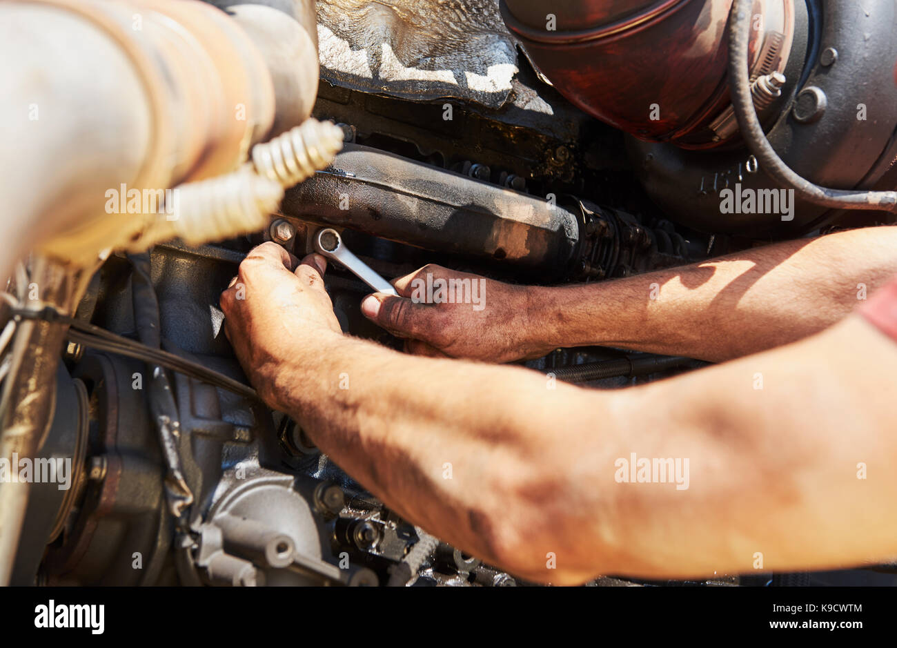 Combine machine service, mechanic repairing motor outdoors Stock Photo ...