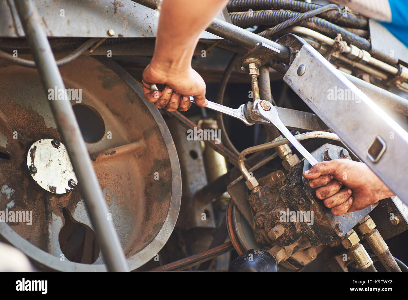 Combine machine service, mechanic repairing motor outdoors Stock Photo ...