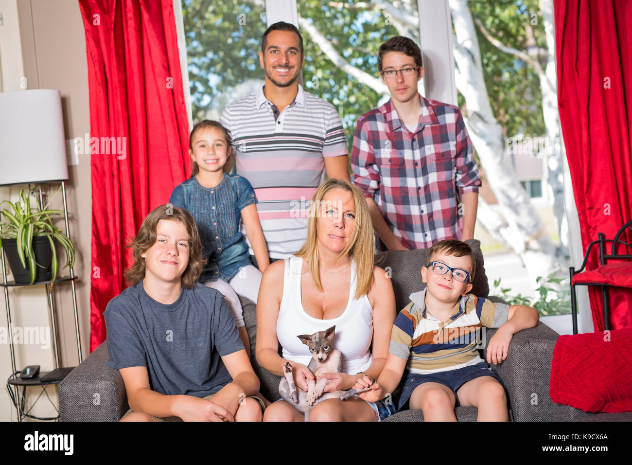 A Family of six on the sofa in the living room Stock Photo - Alamy