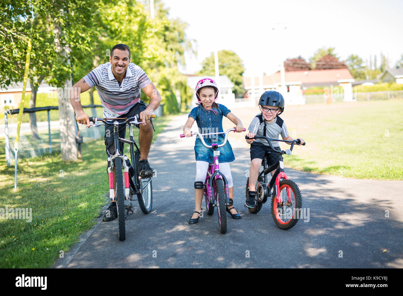 A Dad With Daughter Son Riding Bikes In Park Stock Photo - Alamy