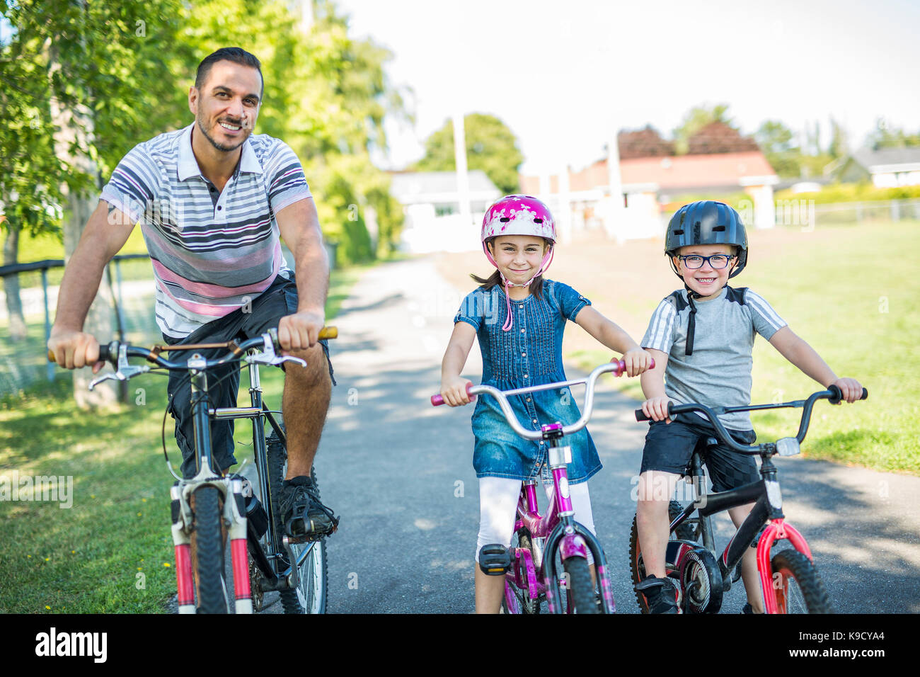 A Dad With Daughter Son Riding Bikes In Park Stock Photo - Alamy