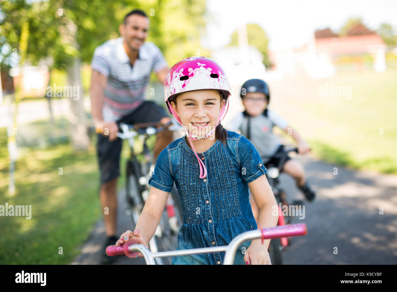 A Dad With Daughter Son Riding Bikes In Park Stock Photo - Alamy