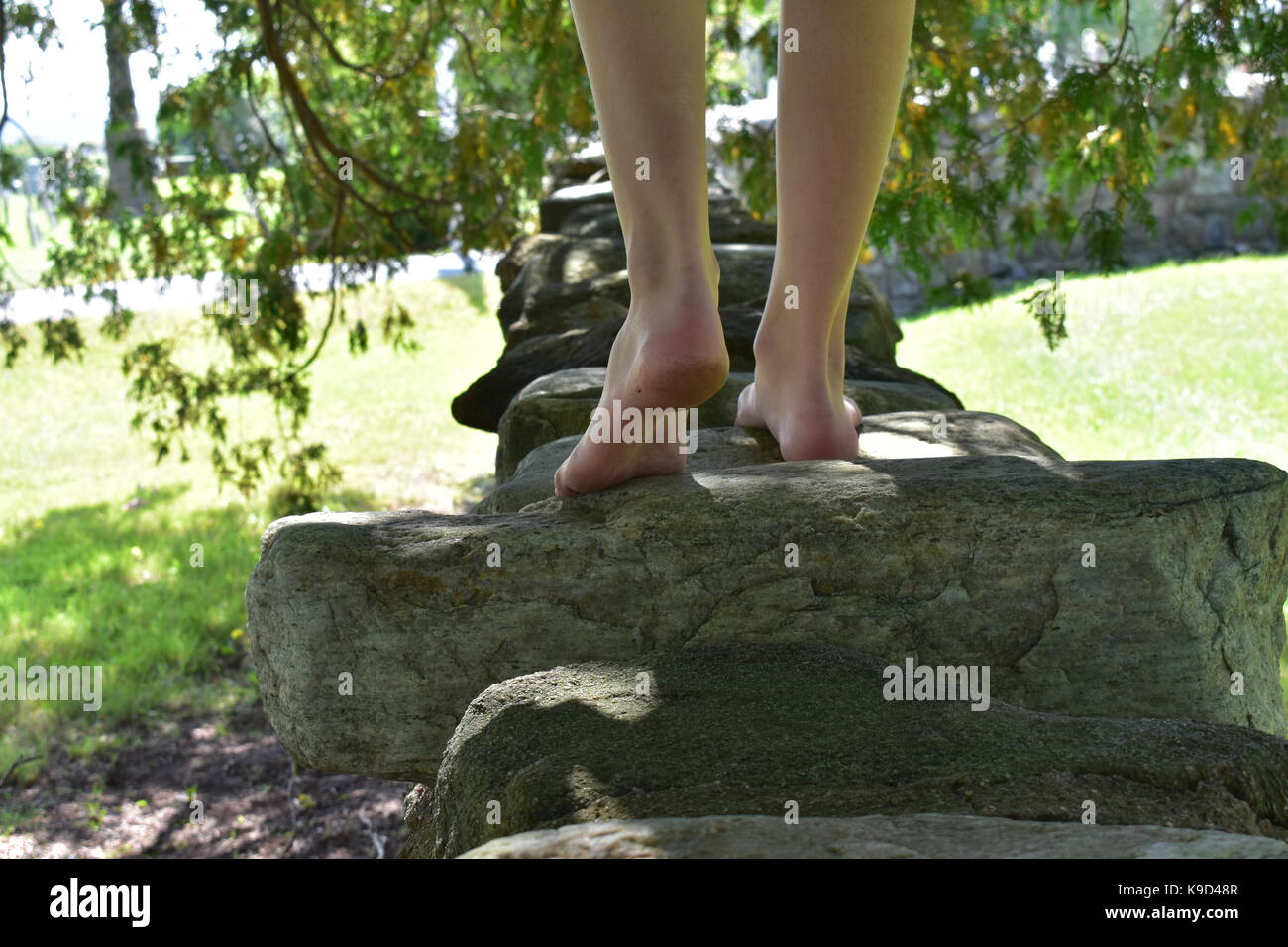 Girl Walking on a long old stone wall Stock Photo - Alamy