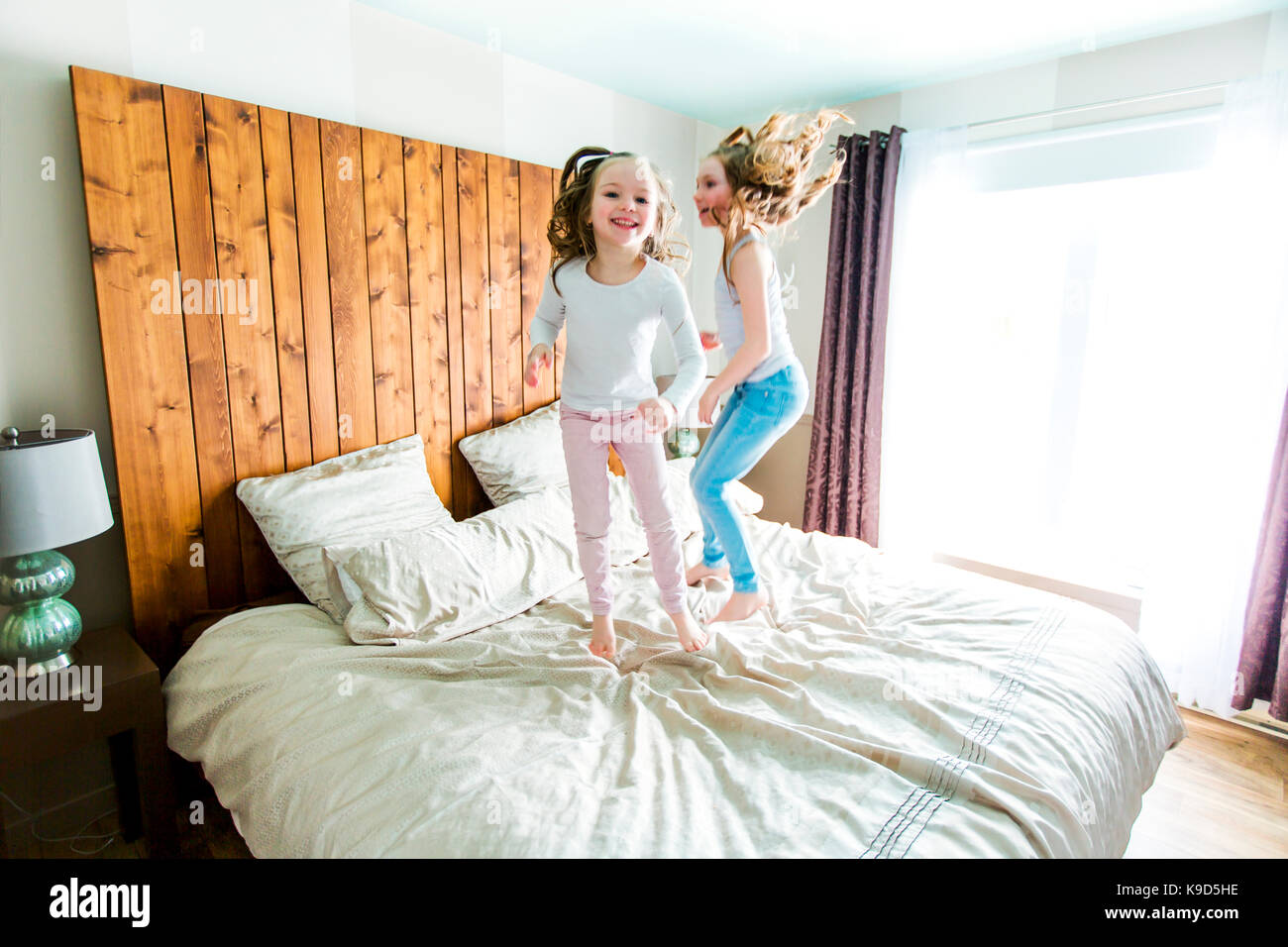 two sister lay on bed at home Stock Photo - Alamy