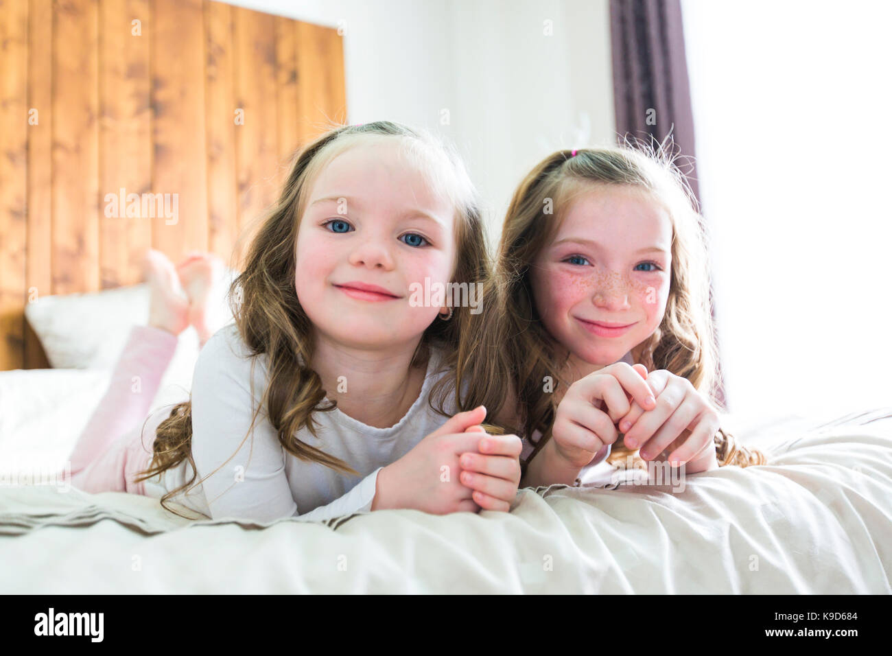 two sister lay on bed at home Stock Photo - Alamy