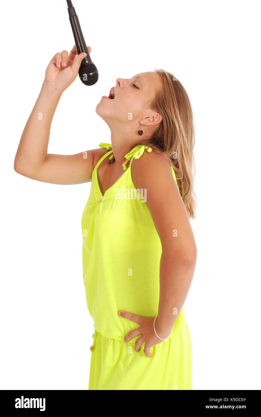 Happy young beautiful girl singing with microphone isolated on white ...