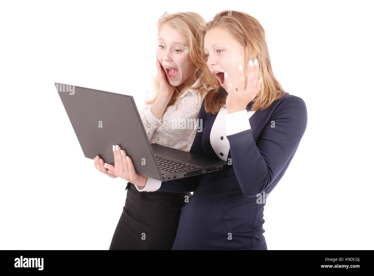 Two shocked girls using laptop isolated on a white background Stock ...