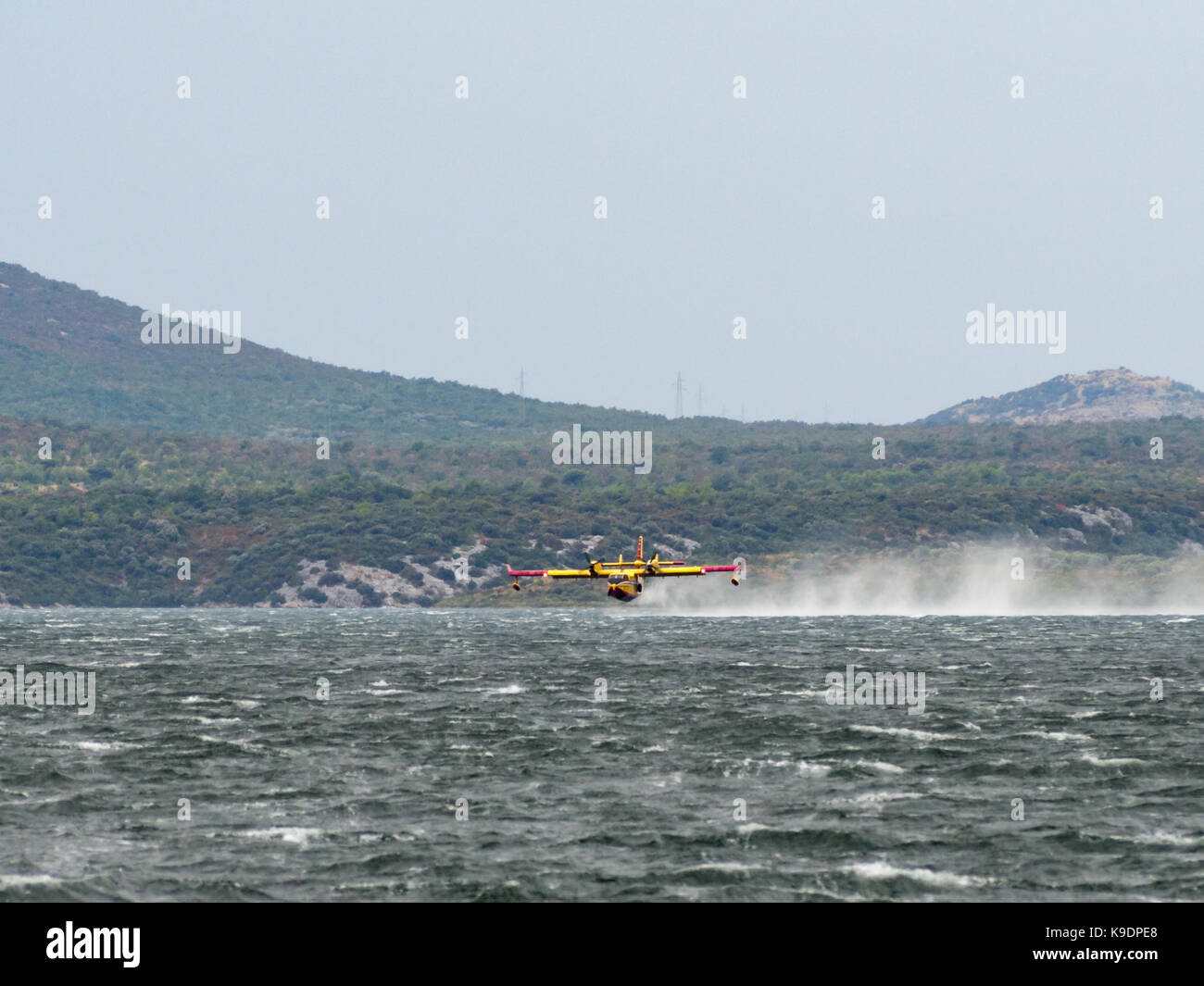 Firefighter airplane, water bomber, air tank taking water from the sea ...
