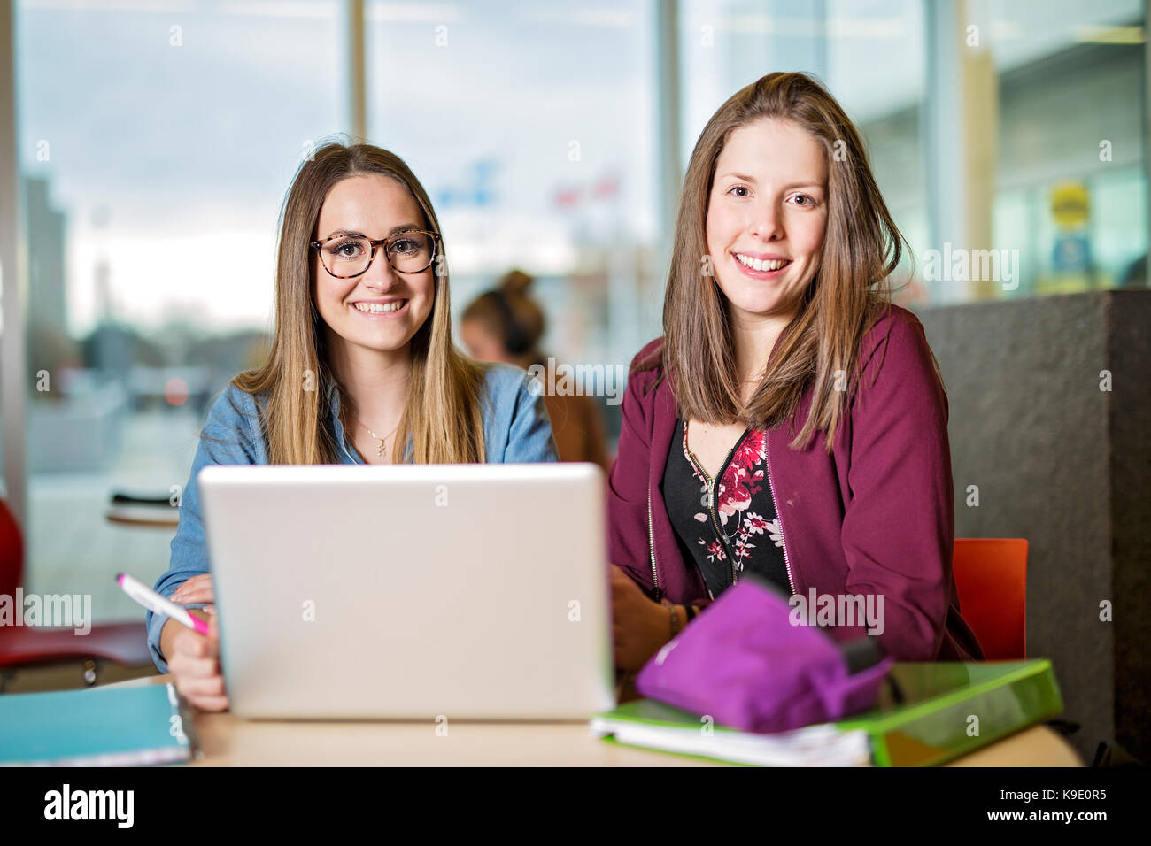 Two pretty female college student studying in the university library ...
