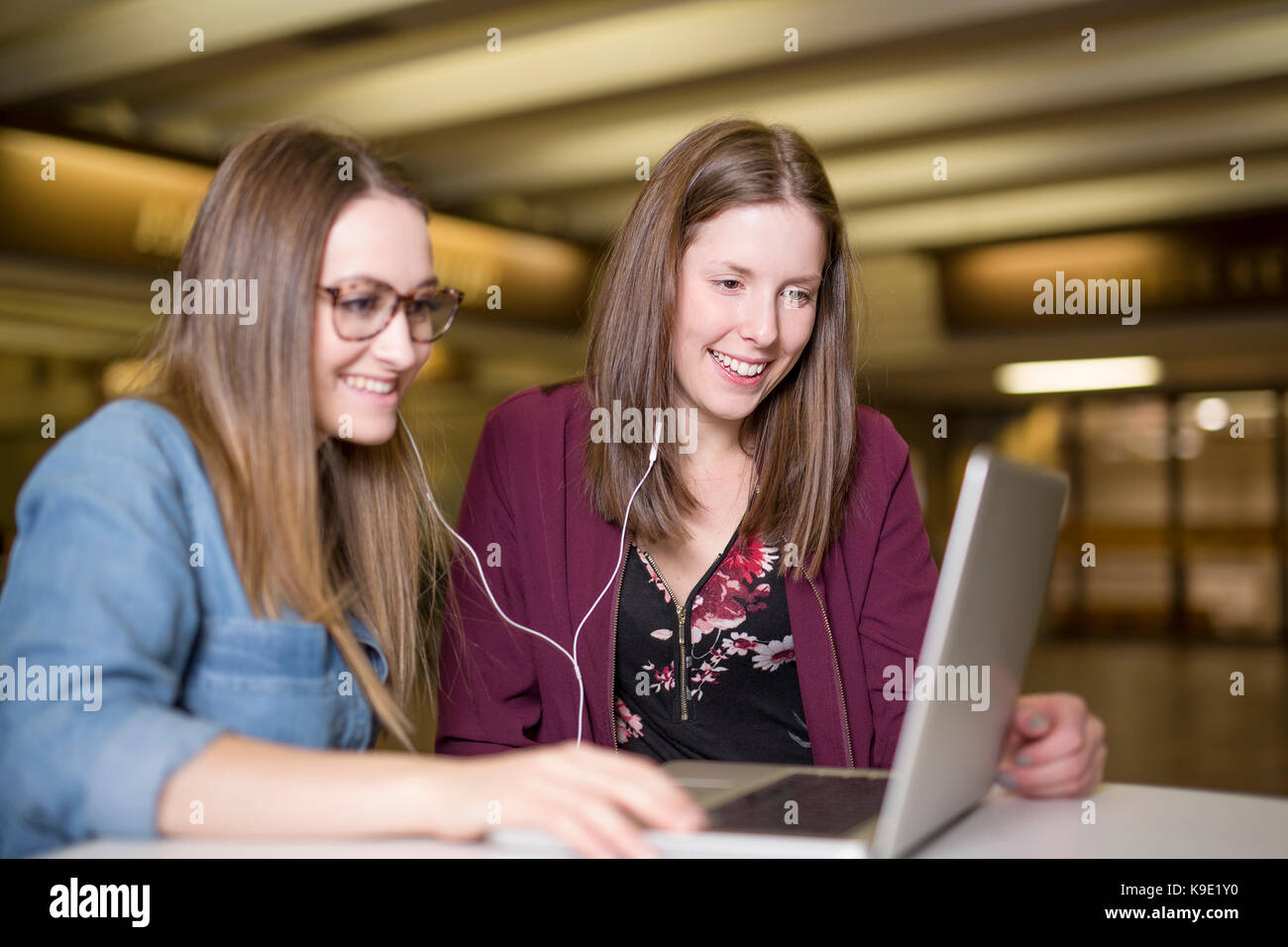 Two pretty female college student studying in the university library ...