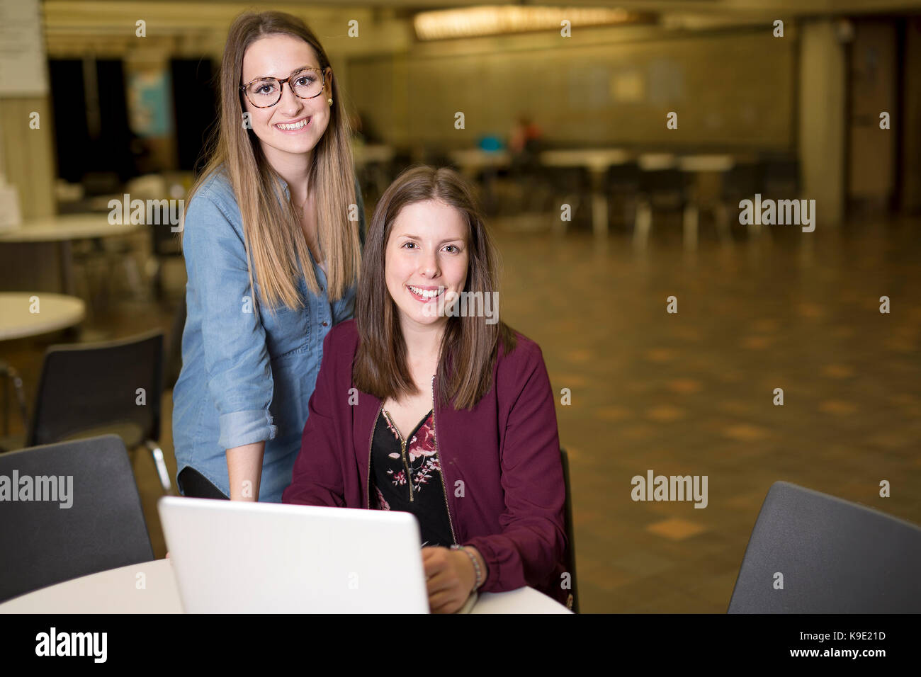 Two pretty female college student studying in the university library ...