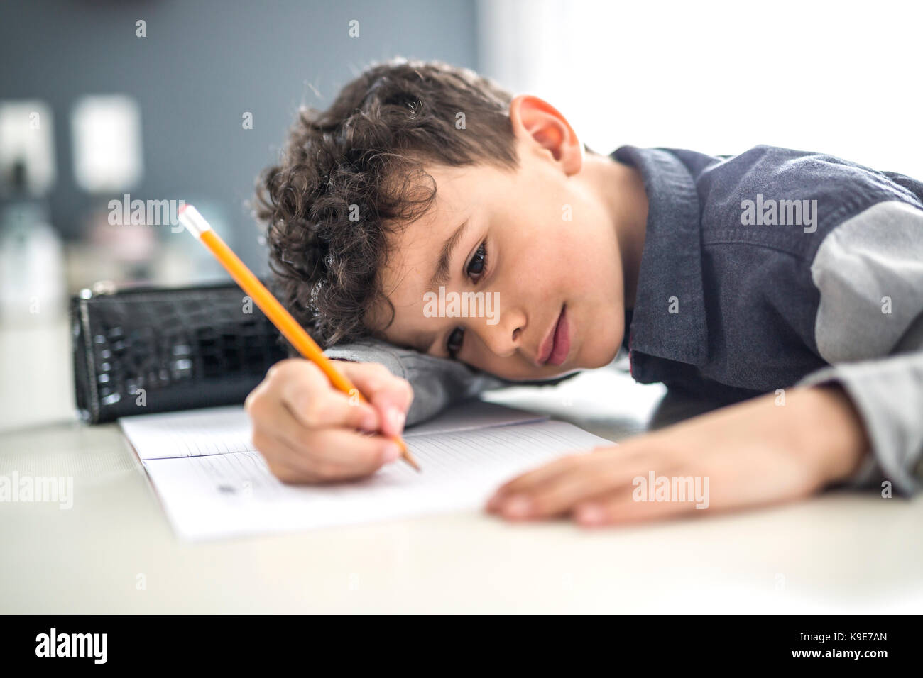 A Cute little boy doing homework at home Stock Photo - Alamy