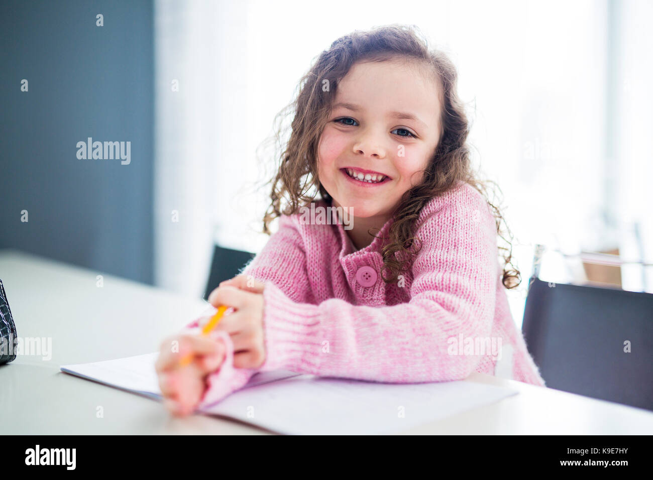 A cute girl writing with pen at the table Stock Photo - Alamy
