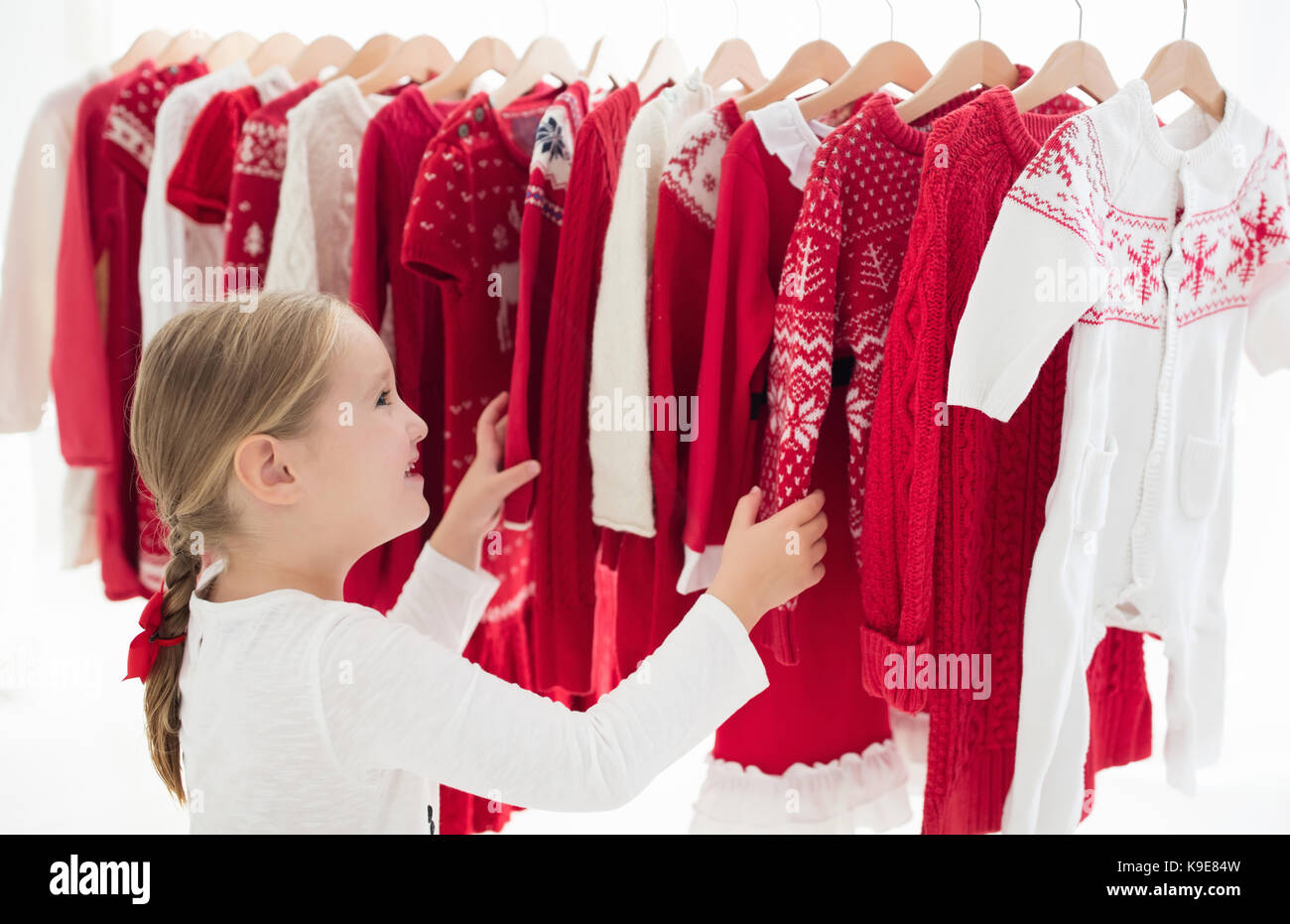 Clothes rack with red Christmas knit wear. Wardrobe with knitted winter ...