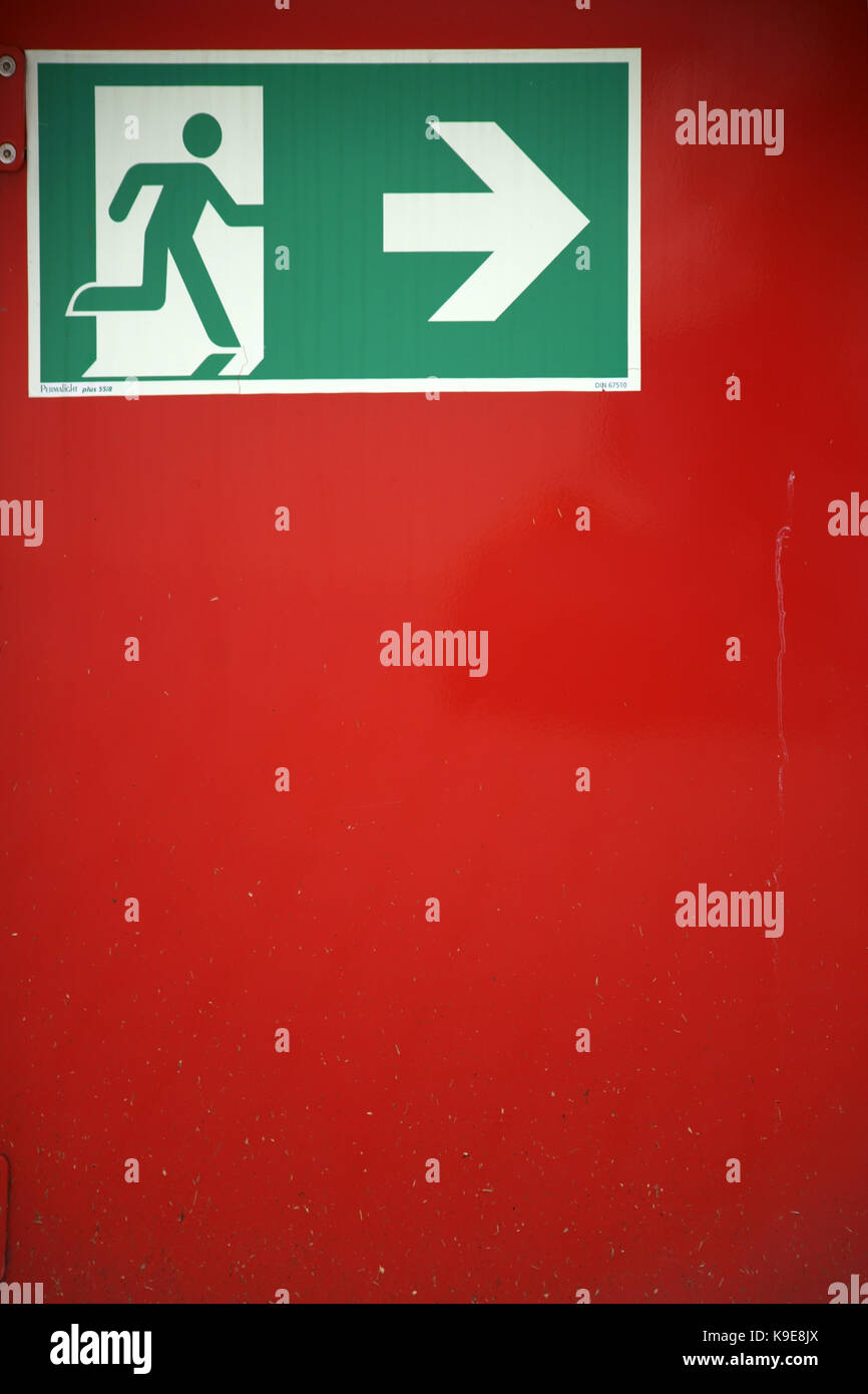 An emergency exit sign and warning sign for an escape route in green on ...