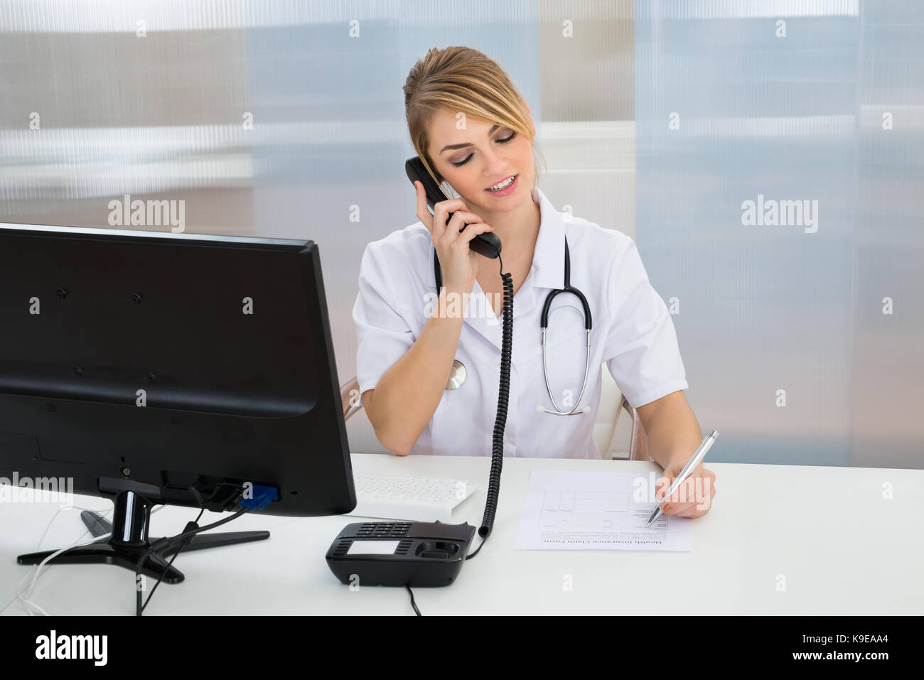 Portrait Of Young Female Doctor Talking On Telephone Stock Photo - Alamy