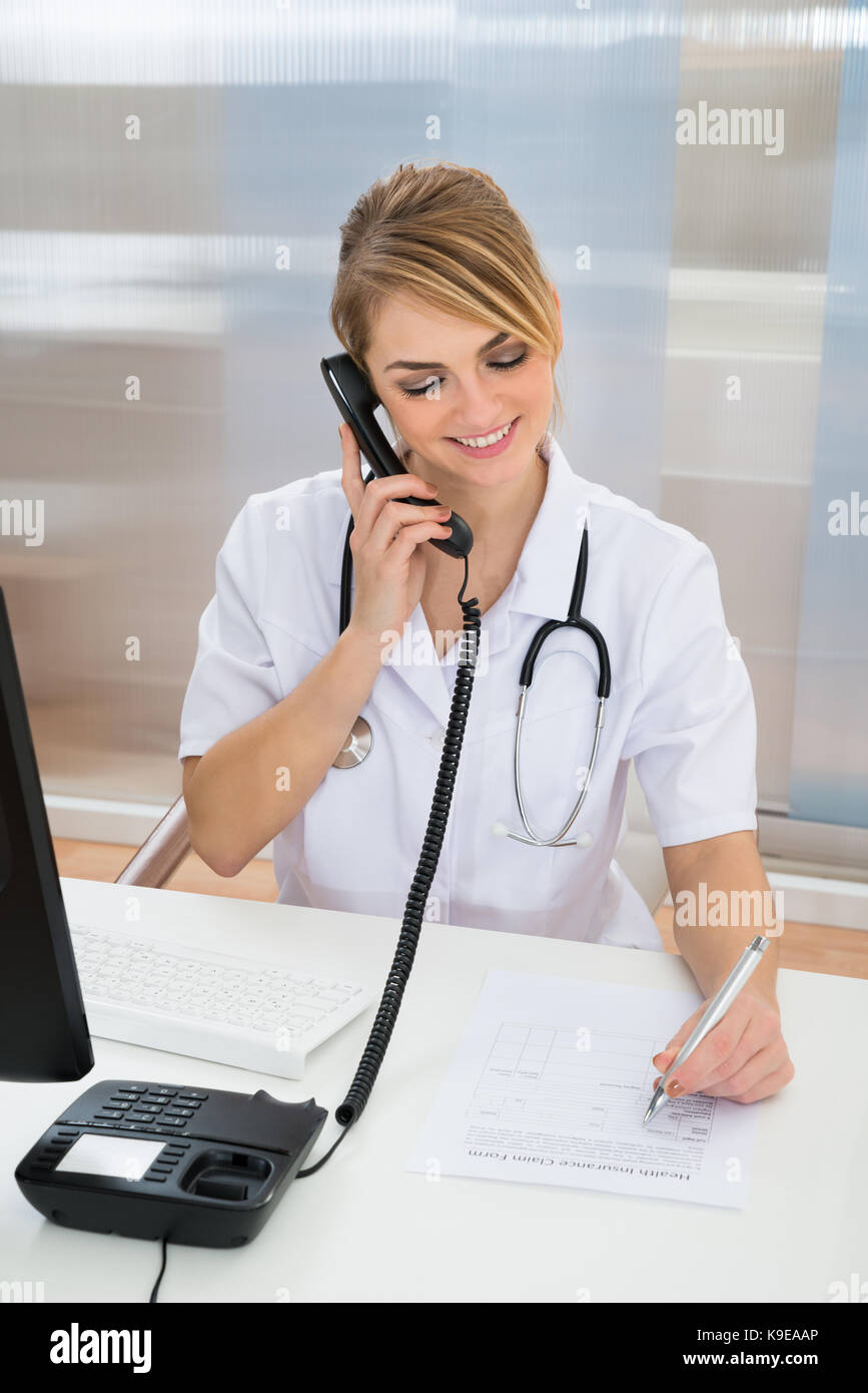 Portrait Of Young Female Doctor Talking On Telephone Stock Photo - Alamy