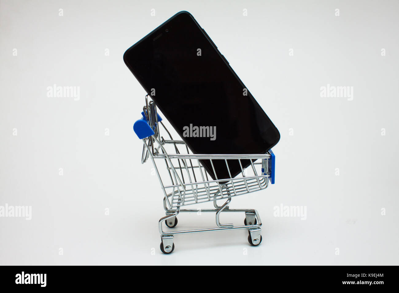 smart phone on a tiny shopping cart isolated Stock Photo - Alamy