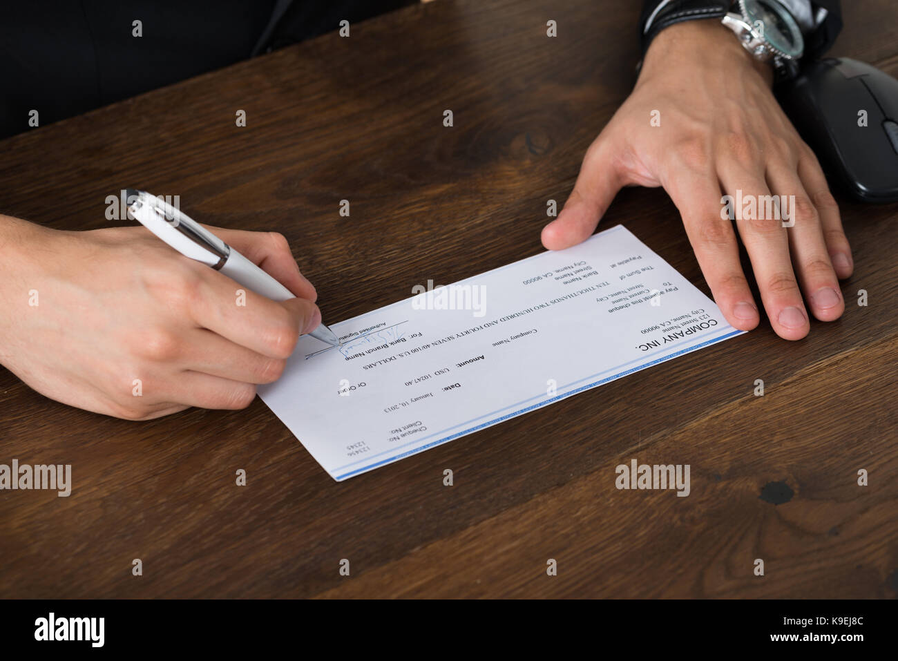 Close-up Of Person Hands With Pen Signing Cheque At Desk Stock Photo ...