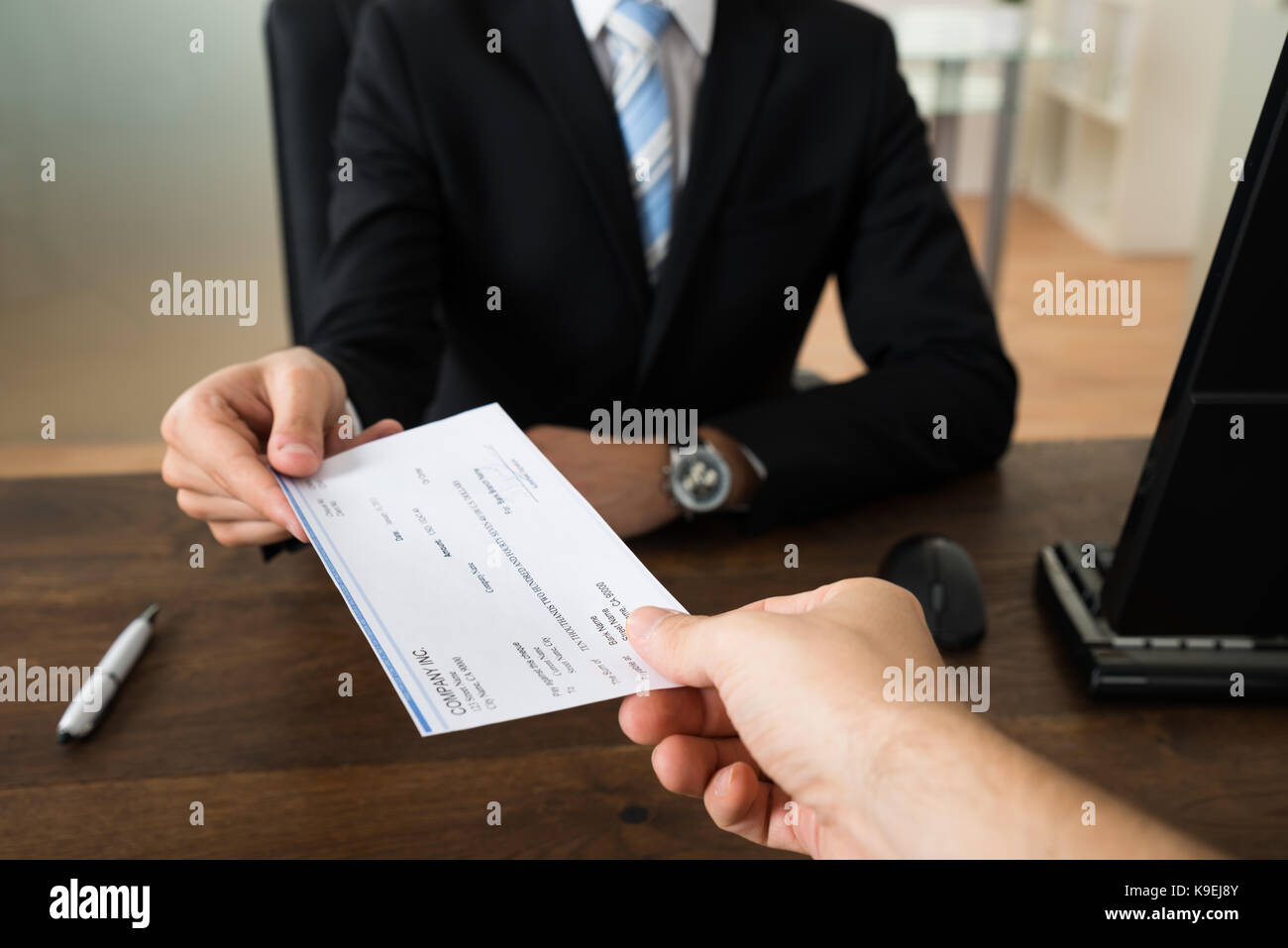Close-up Of Businessman Hands Giving Cheque To Other Person In Office ...