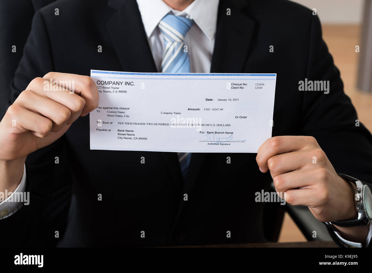 Close-up Of Businessman Showing Signed Cheque In Office Stock Photo - Alamy