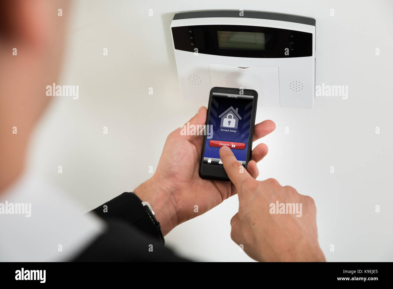 Close-up Of Businessperson Hands Disarming Security System Of Door With ...