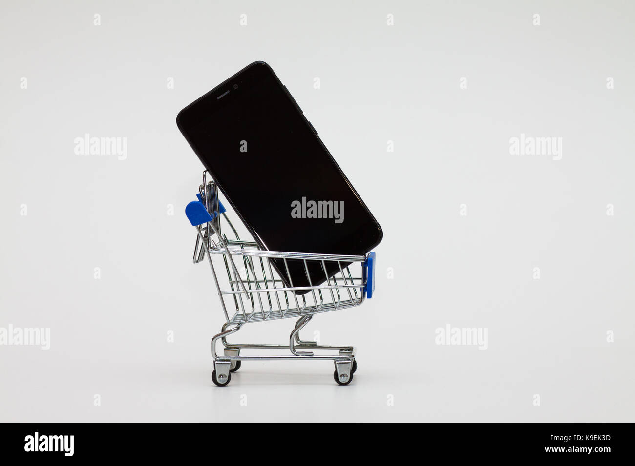 smart phone on a tiny shopping cart isolated Stock Photo - Alamy