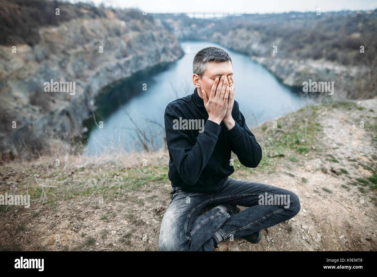 Portrait of stressed despair man closed face by two hands sitting on ...