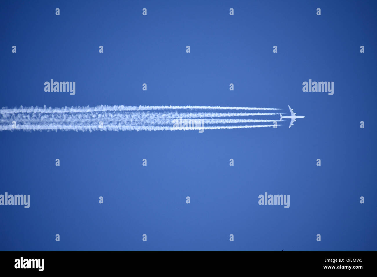 A jet plane flying overhead diagonally with condensation trail Stock ...