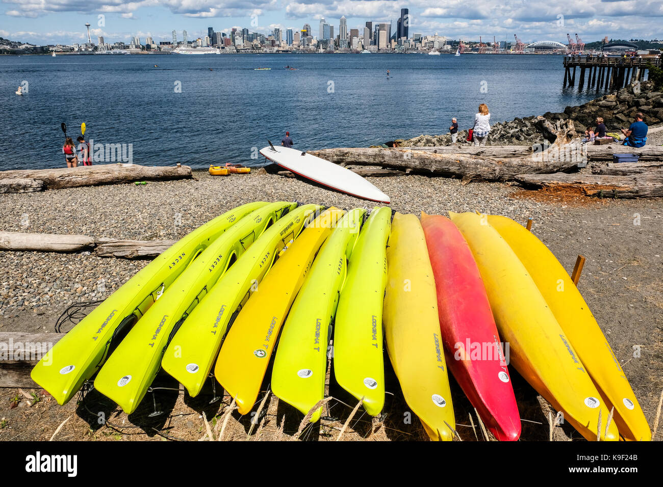 Colorful kayaks laying on the beach of West Seattle with downtown ...