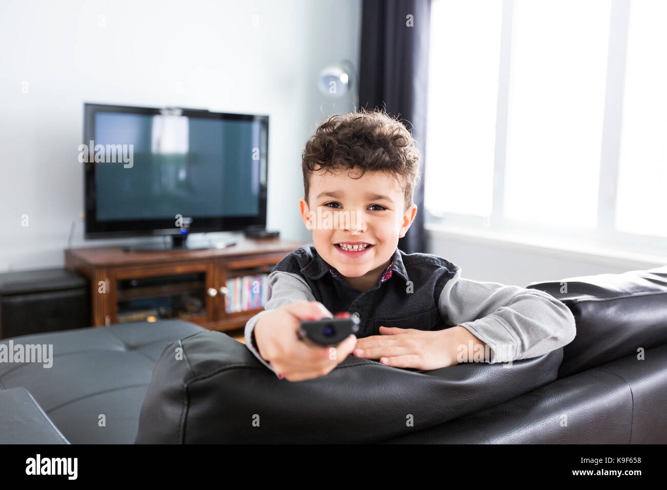 A little boy watching TV lying in the living-room Stock Photo - Alamy