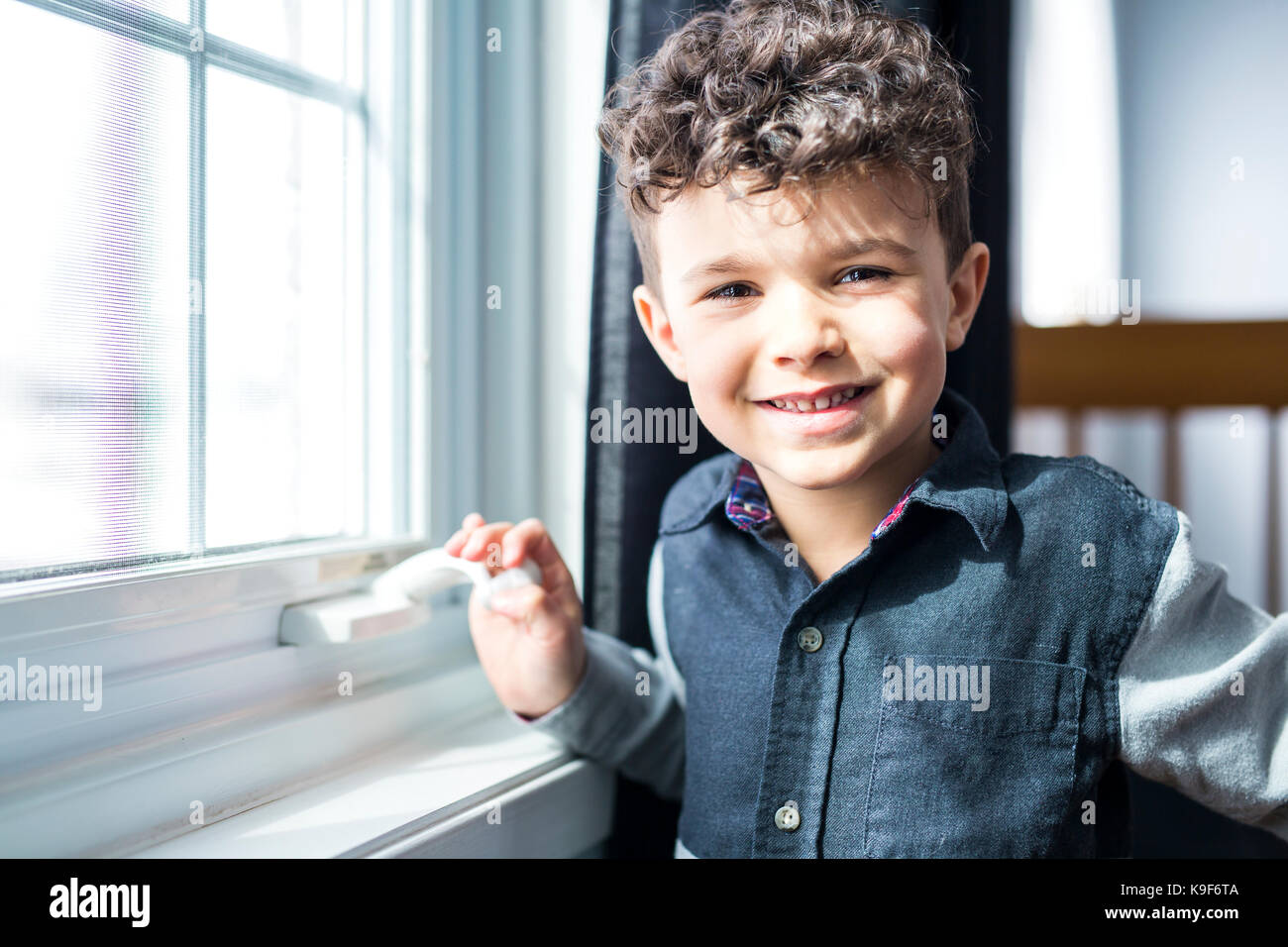 A happy boy close to a window at home Stock Photo - Alamy