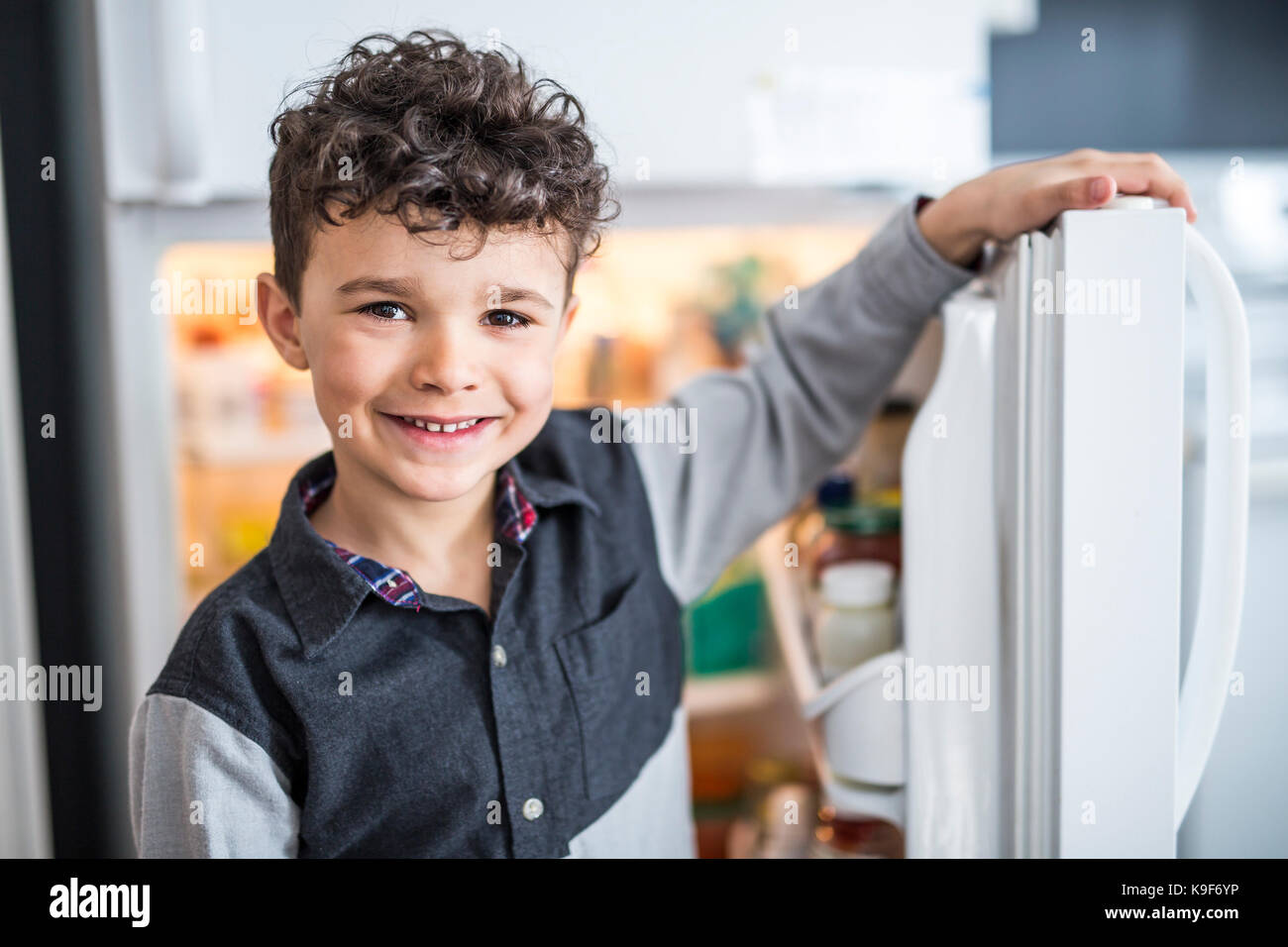 A Young white boy standing in front of open refrigerator Stock Photo ...