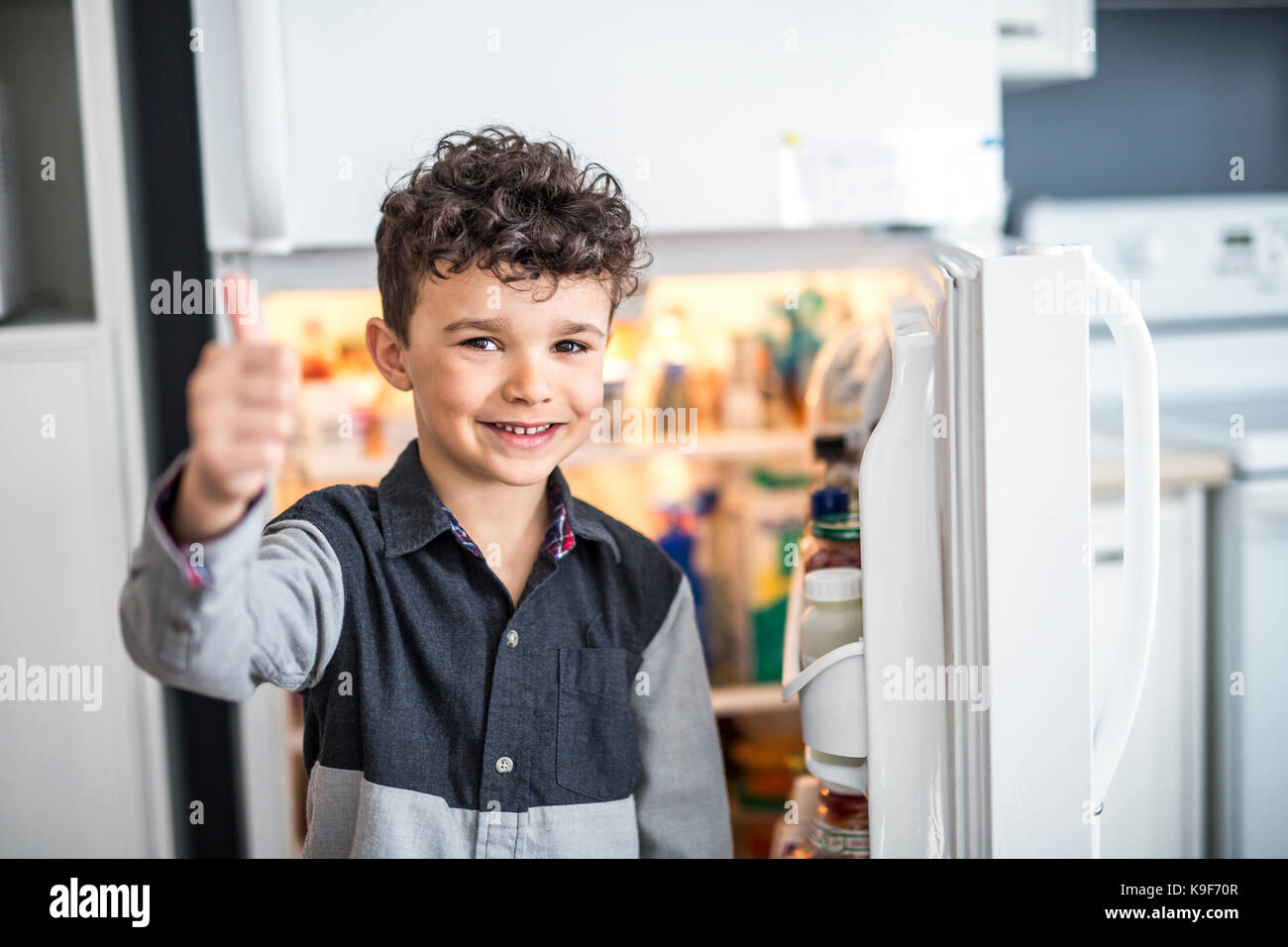 A Young white boy standing in front of open refrigerator Stock Photo ...