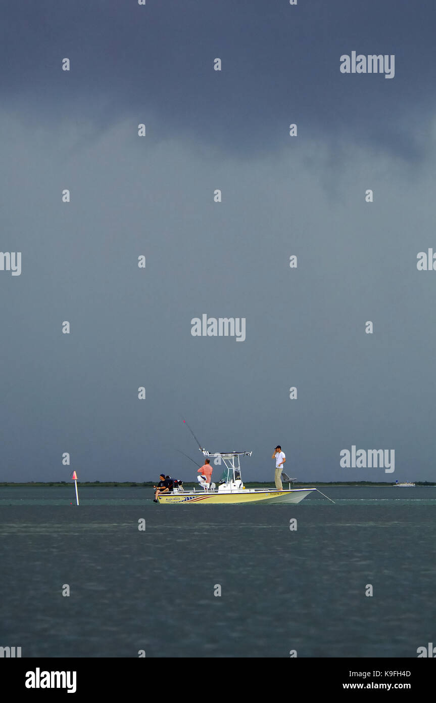 Fishermen talking on a cell phone a storm while fishing during a ...
