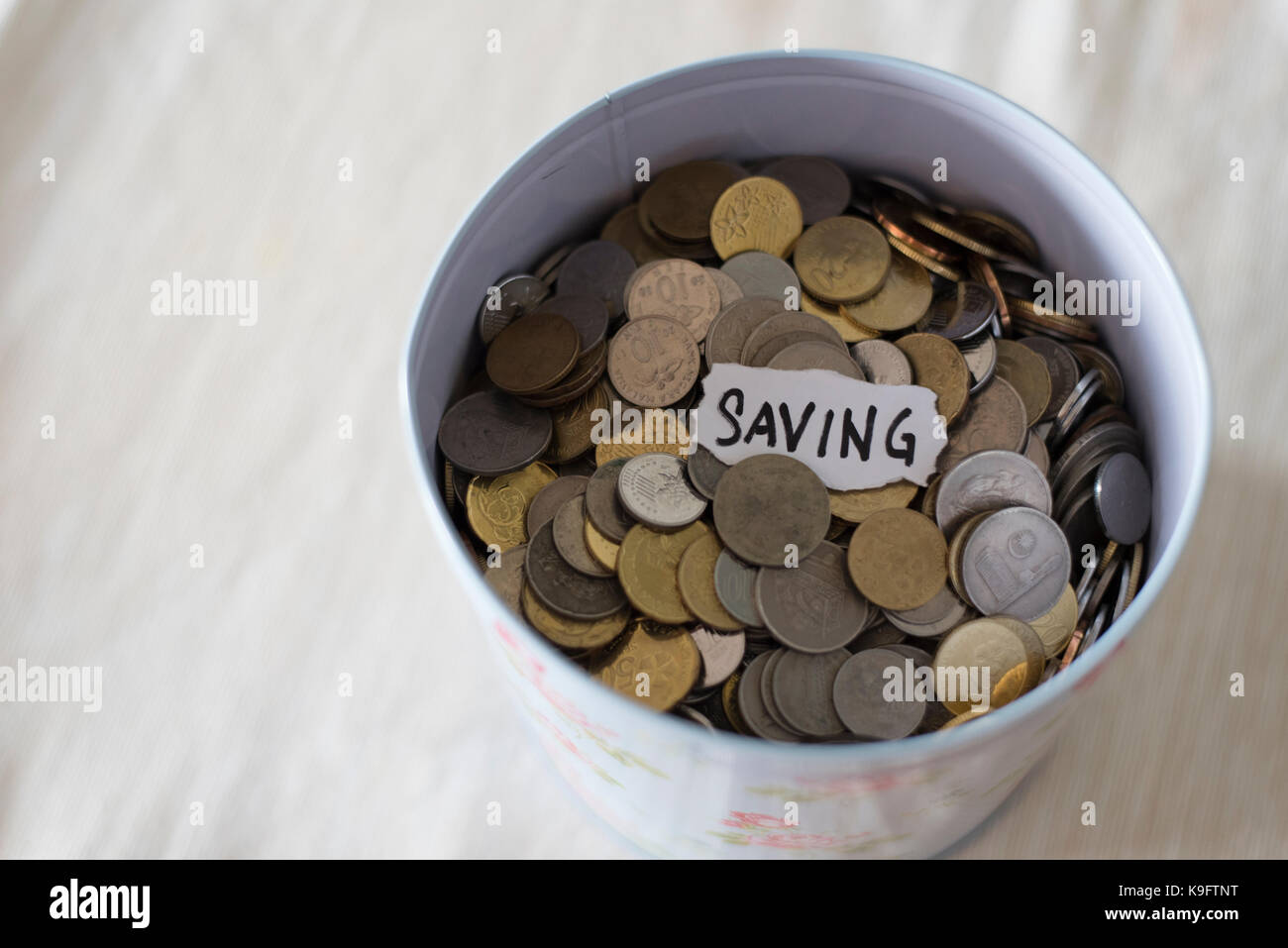 coins in tin with a notes written by the word "saving". saving concept ...