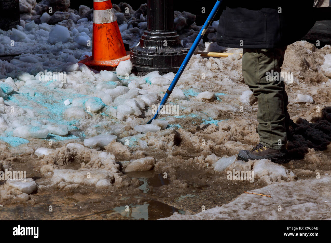 Cleaning the yard of snow. man in a jacket and boots, holding a plastic ...