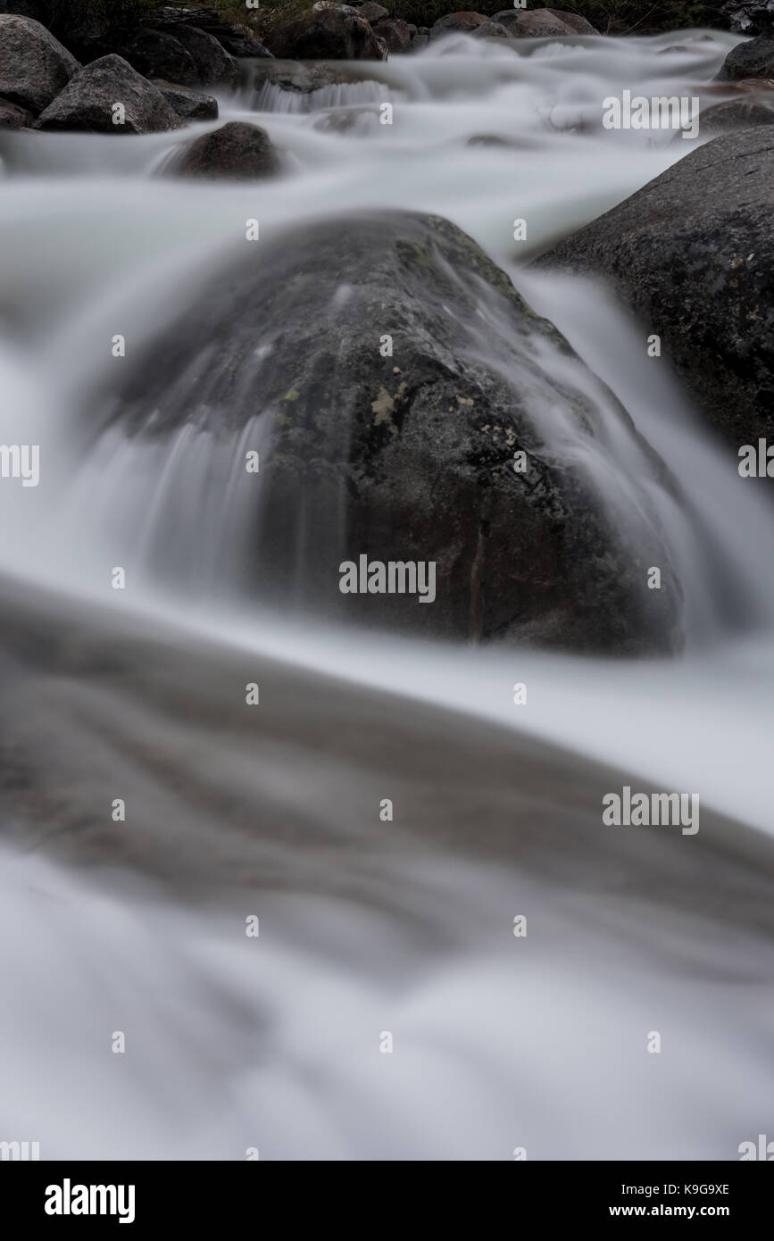 Long Exposure of Snow Melt Over Boulder at base of waterfall Stock ...