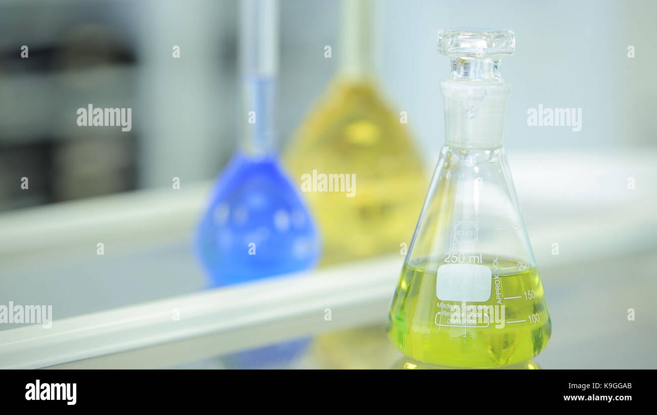 Chemical flasks with green and blue liquid on white background. Test ...