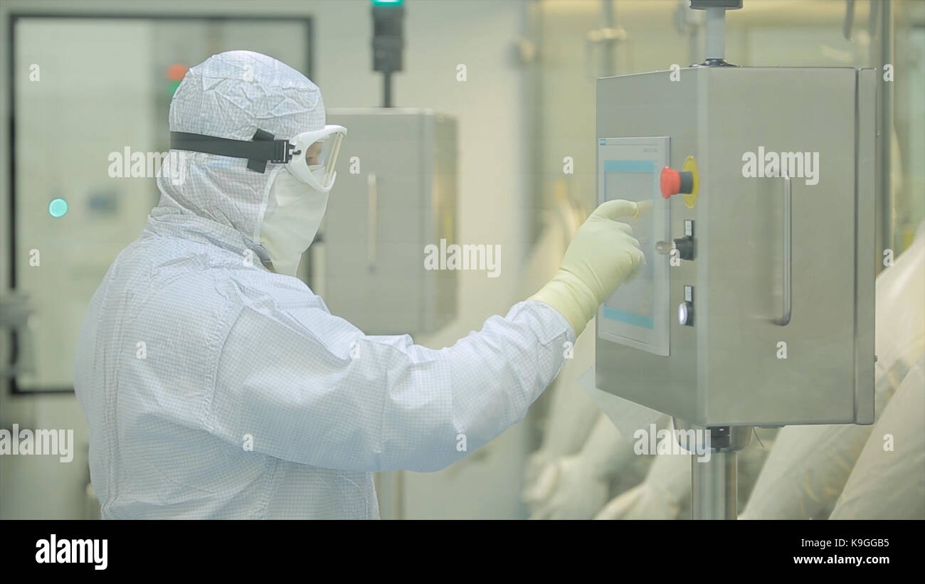Pharmaceutical Production Line Worker at Work. Robotic arm lifting ...
