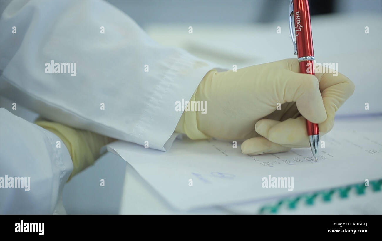 Midsection of doctor writing on paper at clinic. Close up of patient ...