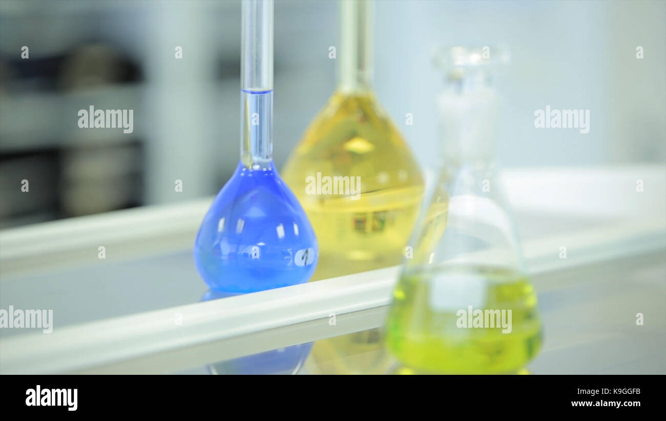 Chemical flasks with green and blue liquid on white background. Test ...