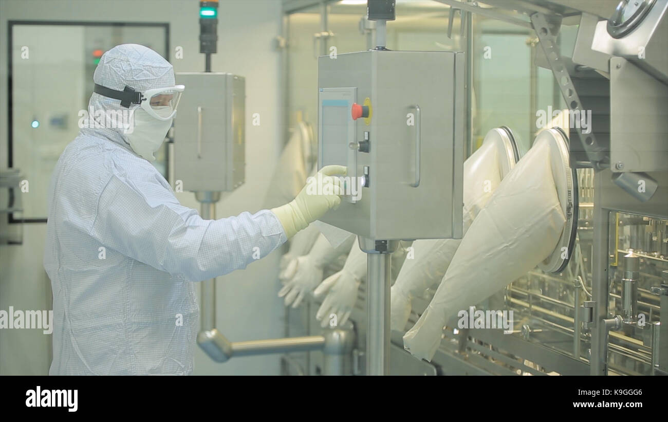 Pharmaceutical Production Line Worker at Work. Robotic arm lifting ...