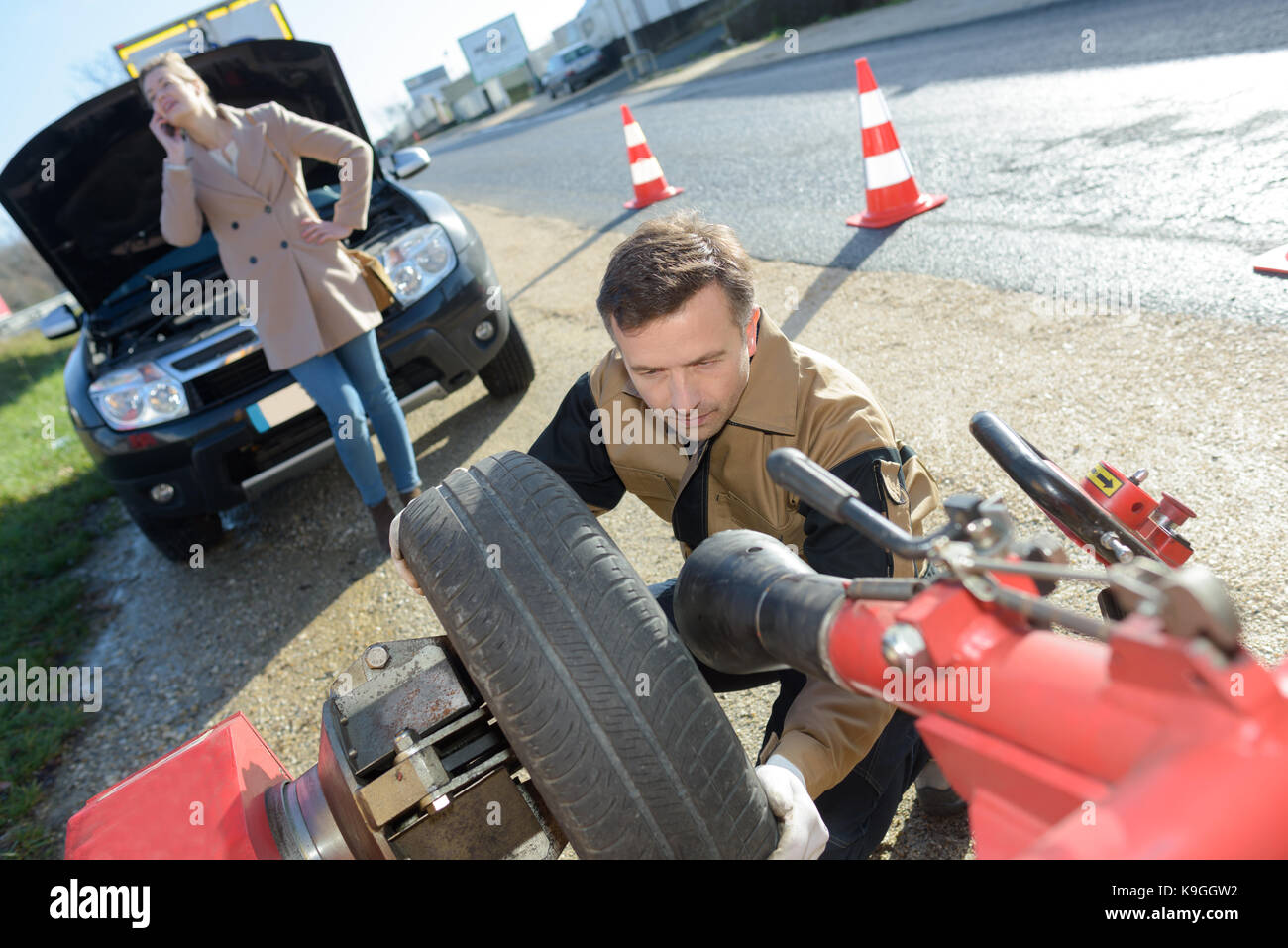 young woman and mechanic assistance on roadside with car breakdown ...