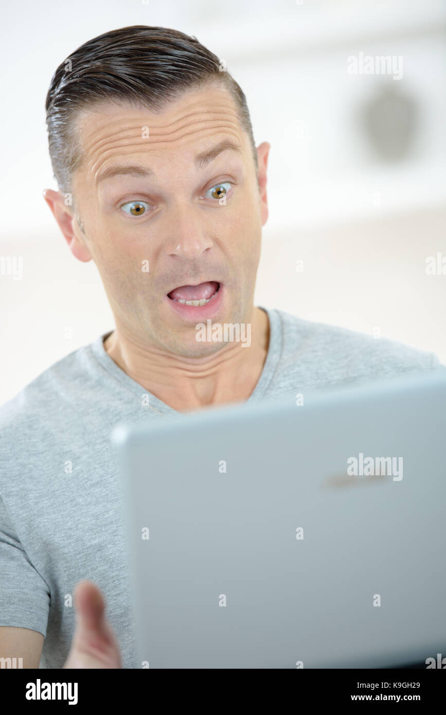 surprised man looking into computer screen Stock Photo - Alamy
