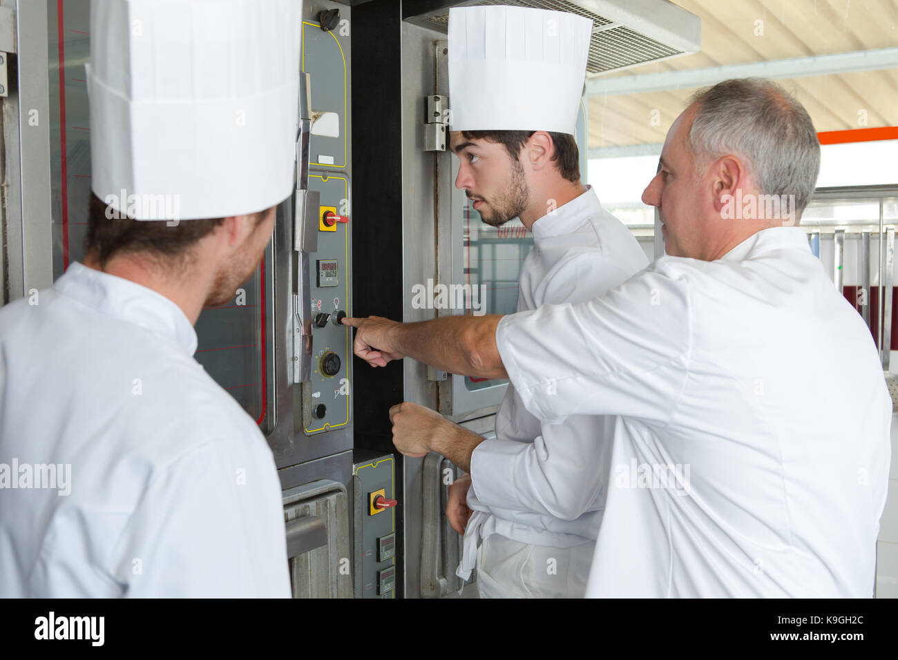 team of bakers cooking dough in a commercial kitchen Stock Photo - Alamy